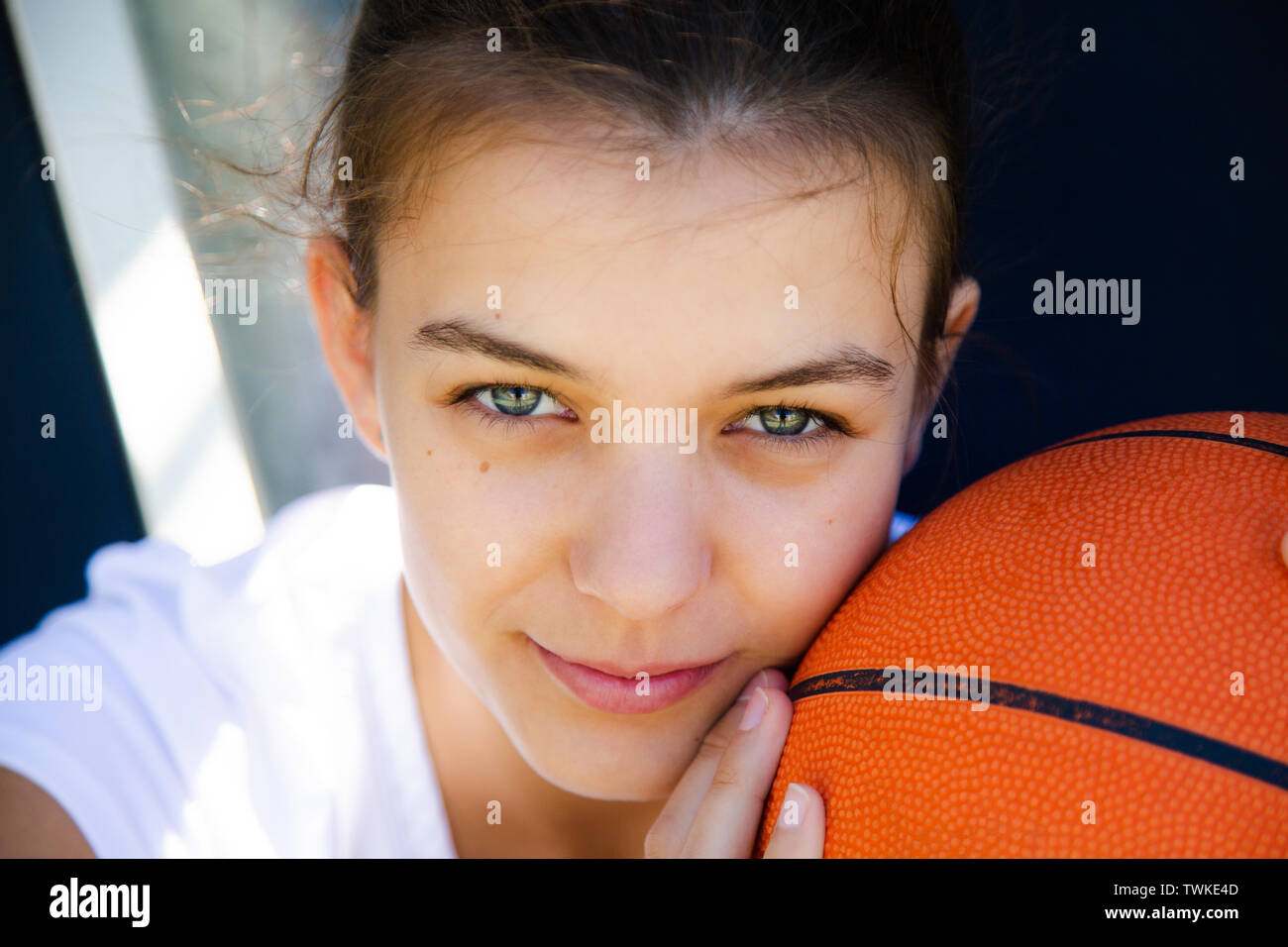 Portrait of a beautiful and young female basketball player with face ...