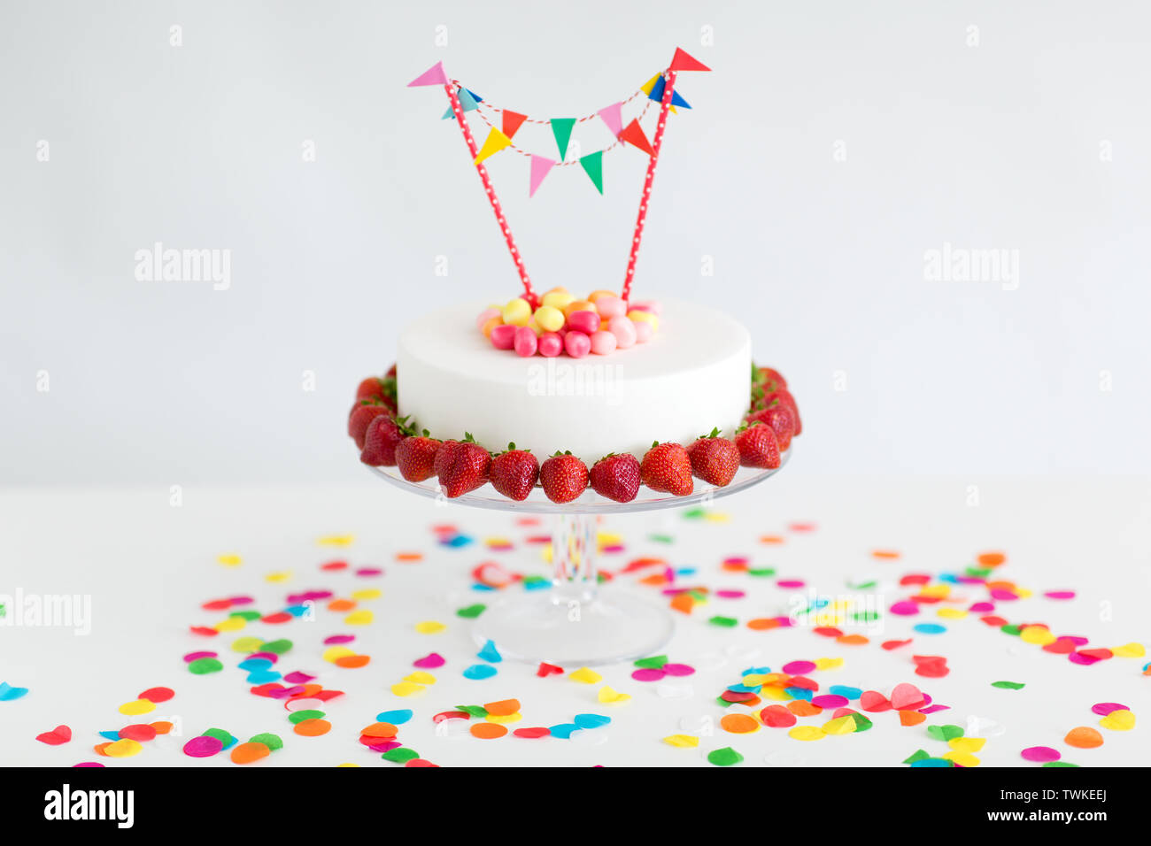 close up of birthday cake with garland on stand Stock Photo - Alamy