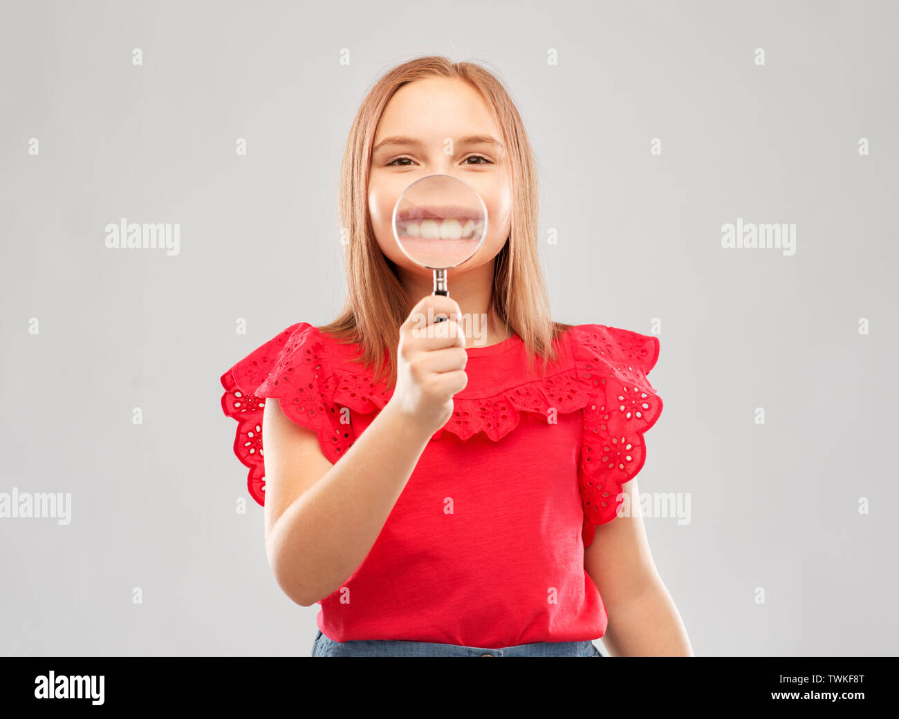 happy girl with magnifying glass over her teeth Stock Photo - Alamy