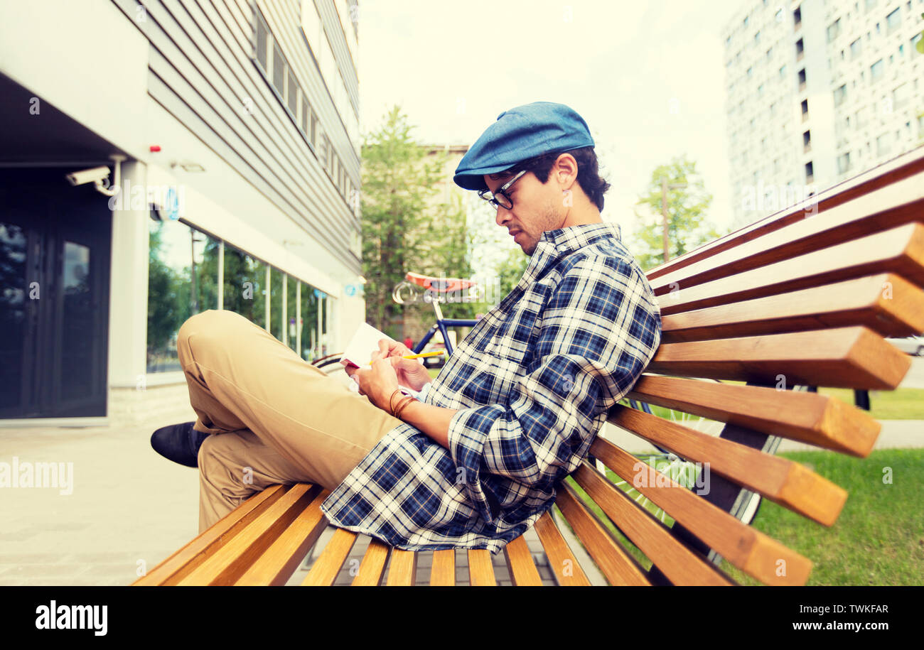 man with notebook or diary writing on city street Stock Photo - Alamy