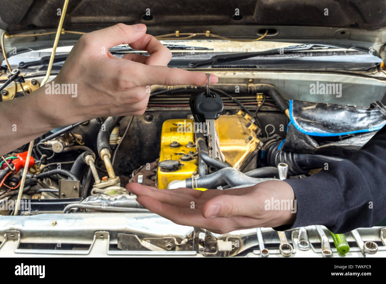 Hand handing over car keys with finger and hand receiving on engine ...