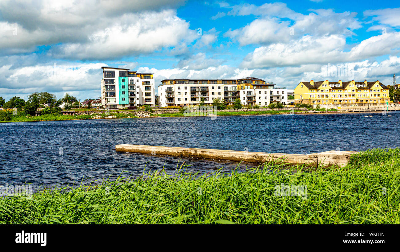Shannon river with calm waters, some buildings in the city of Athlone ...