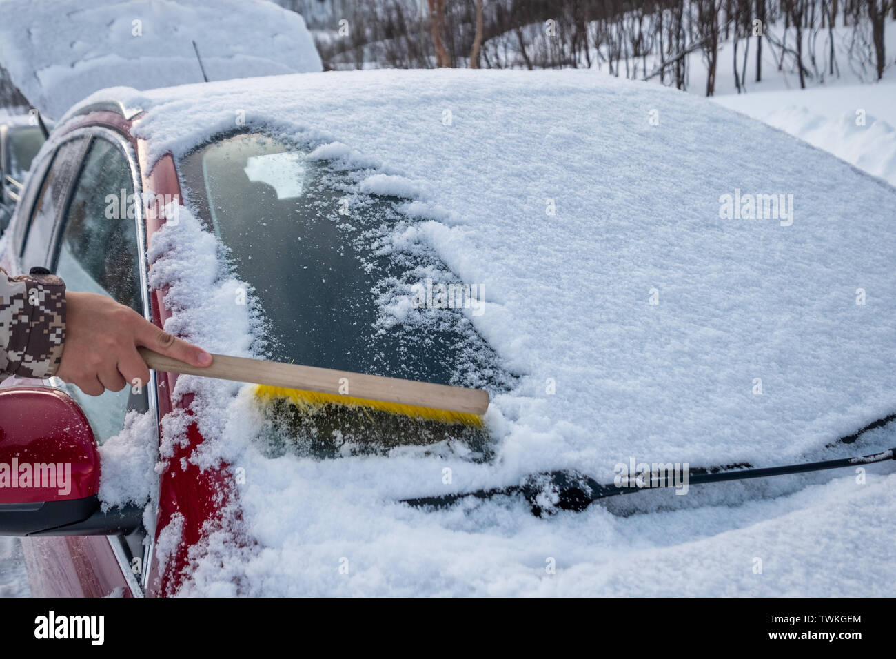 Hand using brush sweeping snow on car windscreen in winter Stock Photo ...