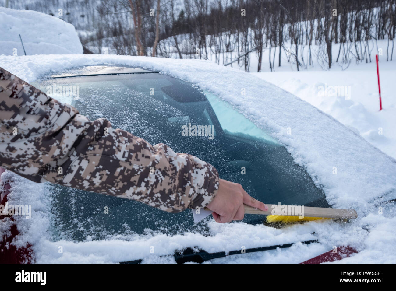 Hand using brush sweeping snow on car windscreen in winter Stock Photo ...