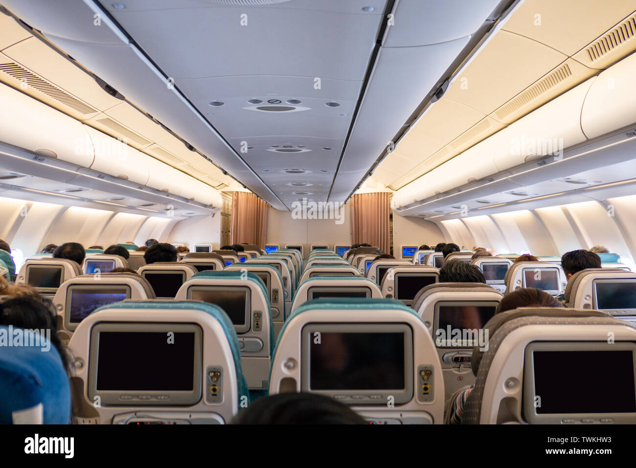 Airline seat rows with digital display on airplane Stock Photo - Alamy