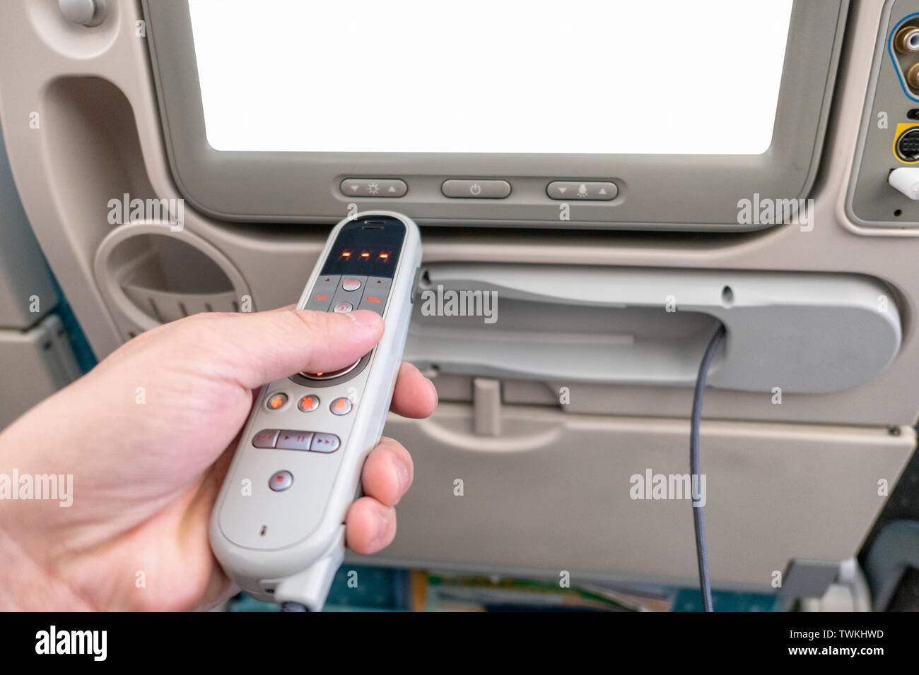 Hand holding remote with blank display on airplane Stock Photo - Alamy