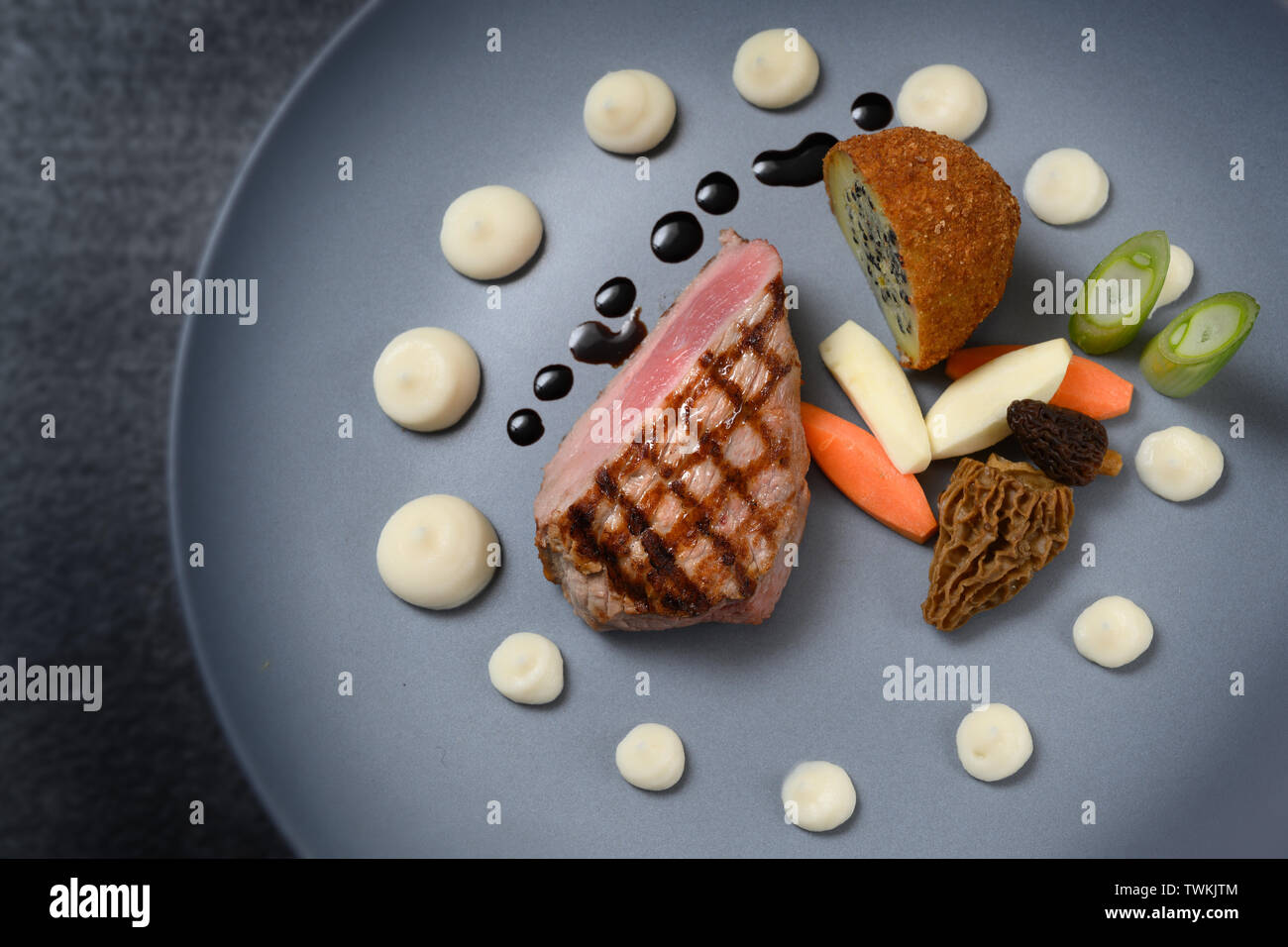 festive dish with roasted veal, morels, vegetables and a fried potato ...