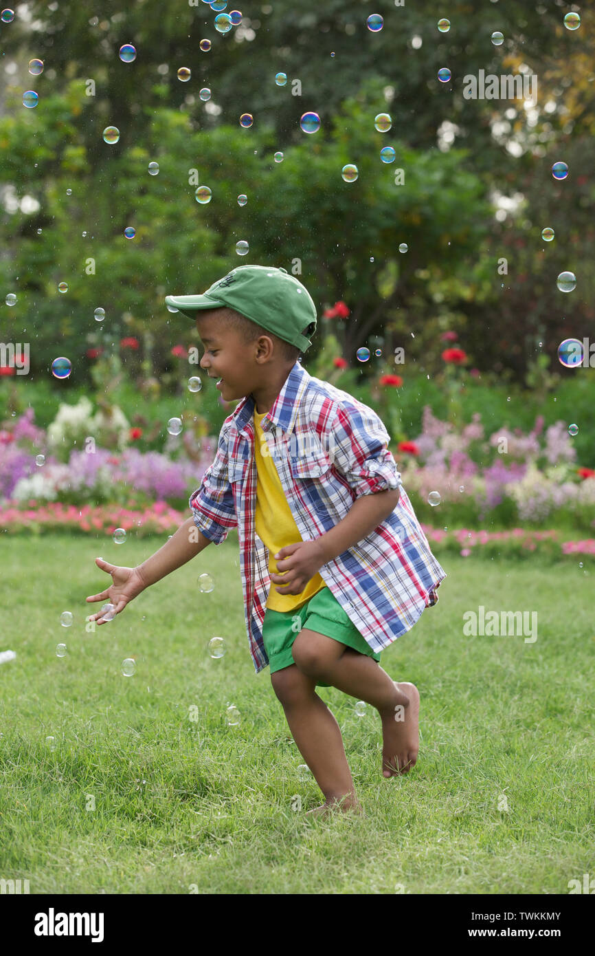 Boy trying to hold floating bubbles Stock Photo - Alamy