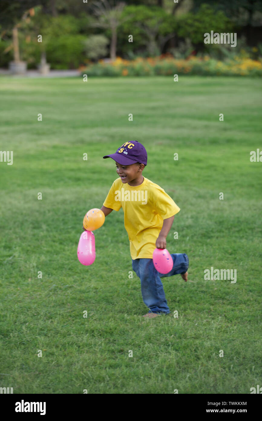 Boy running with balloons Stock Photo - Alamy