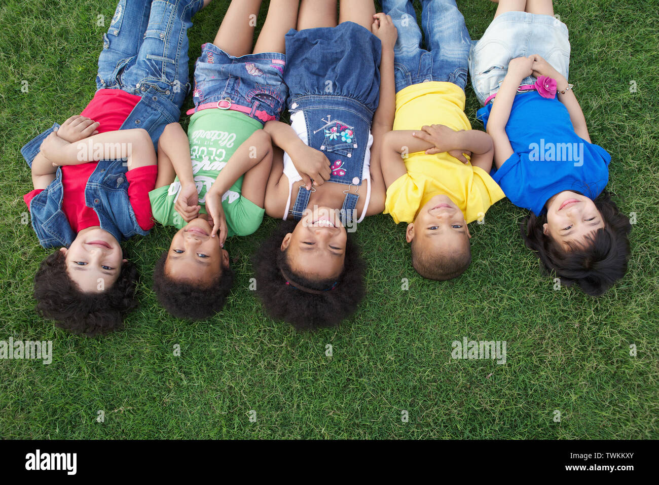 Group of children lying on grass Stock Photo - Alamy