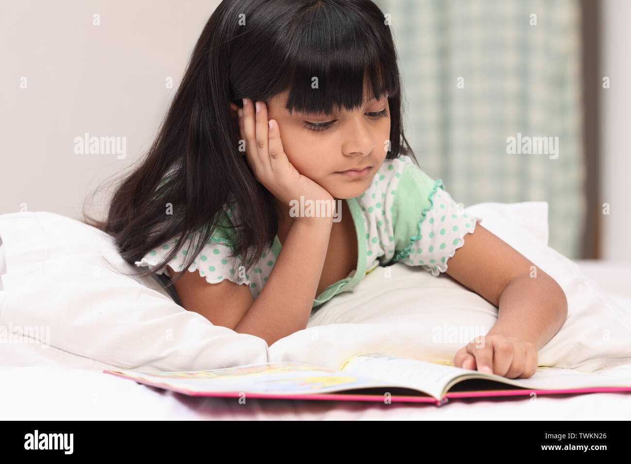 Girl reading a storybook Stock Photo - Alamy