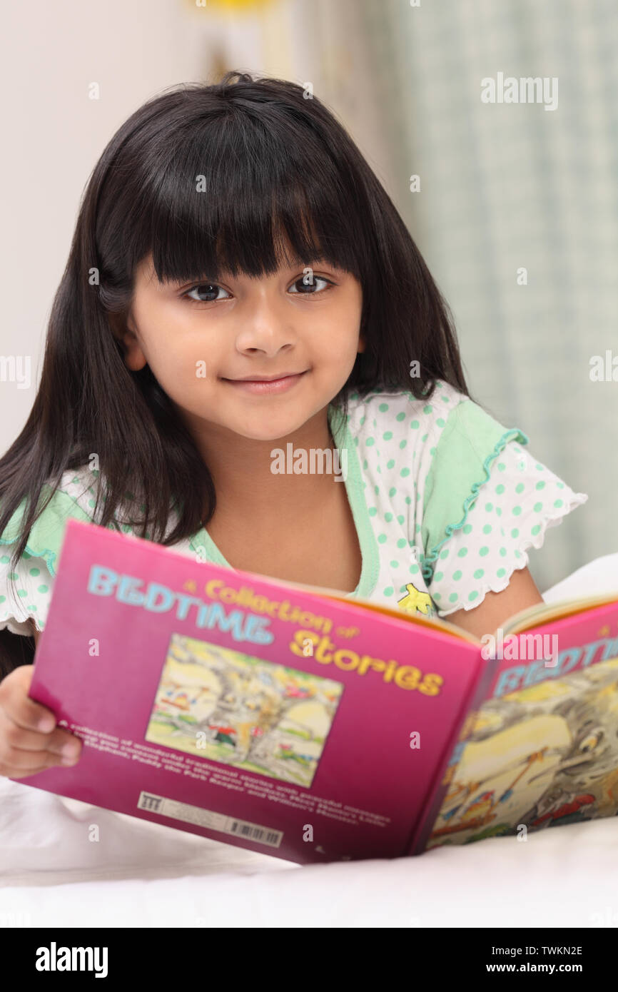 Girl reading a storybook Stock Photo - Alamy