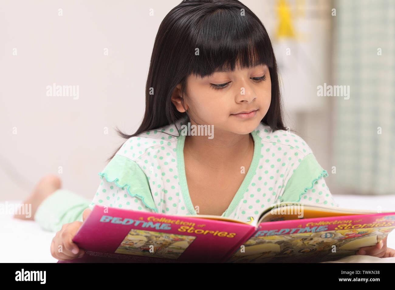 Girl reading a storybook Stock Photo - Alamy