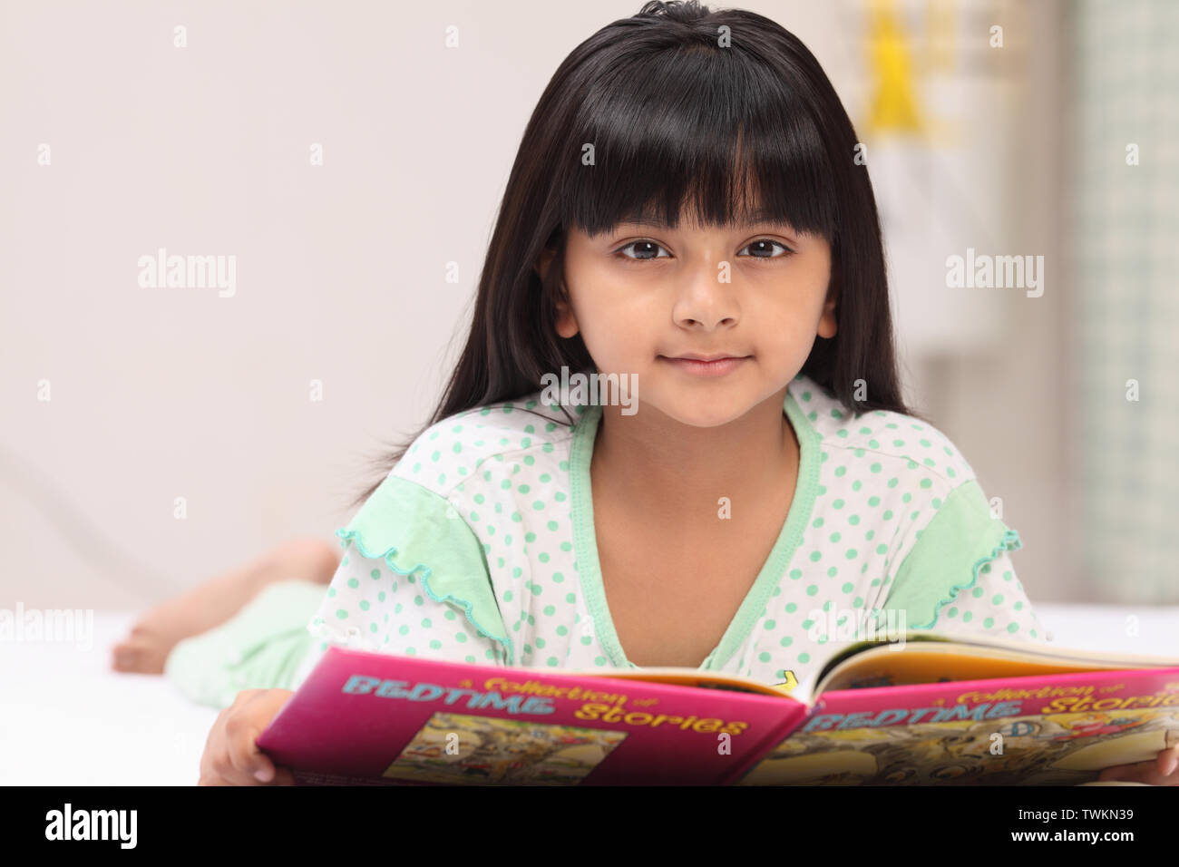 Girl reading a storybook Stock Photo - Alamy
