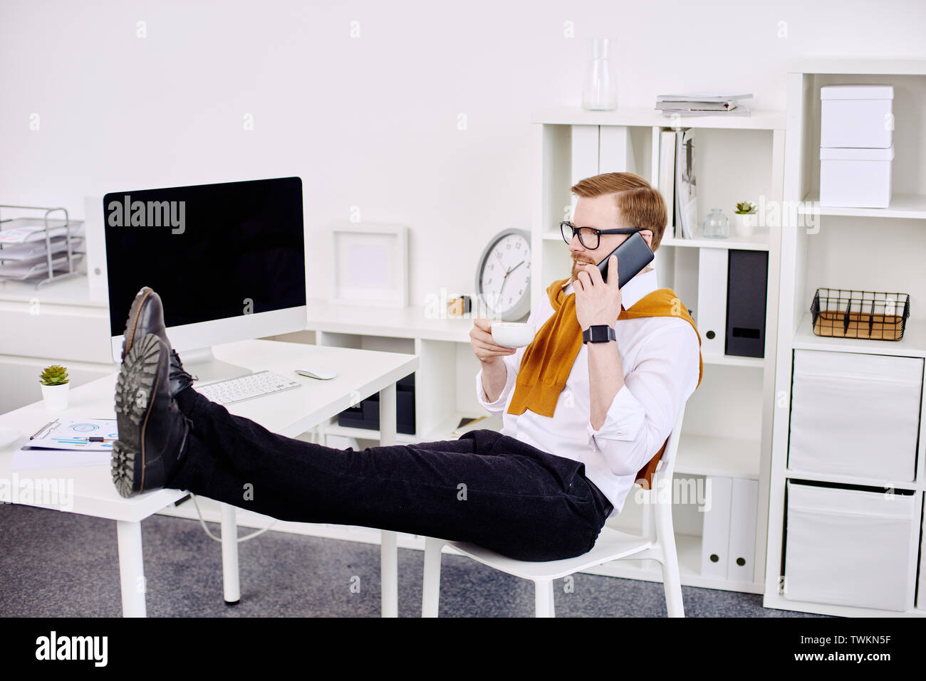 Mid age businessman drinking tea at the computer in the office Stock ...