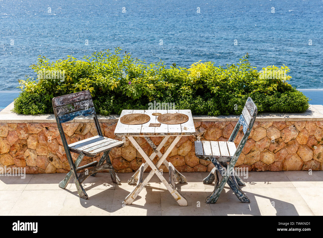 Wooden table and chairs at a outdoor cliff cafe with ocean view, Amed ...