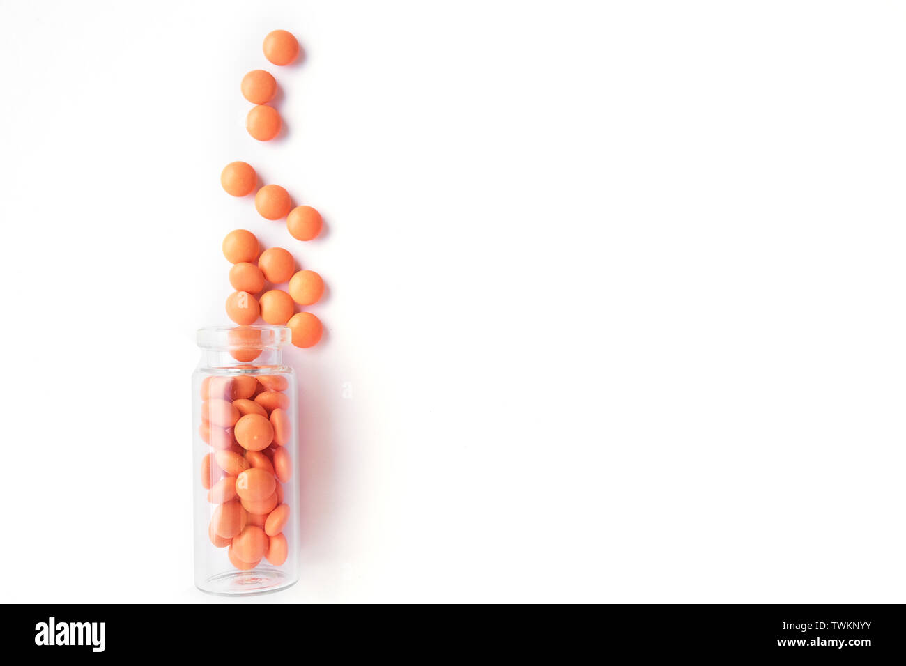 Orange tablets from glass bottle on white background. copyspace for ...