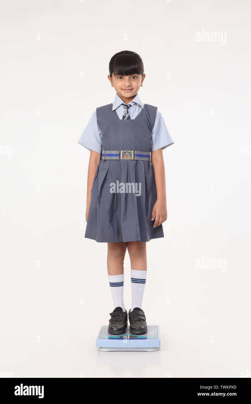 Girl weighing herself on a weight scale Stock Photo - Alamy