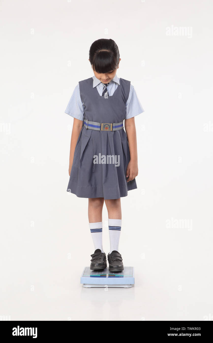 Girl weighing herself on a weight scale Stock Photo - Alamy