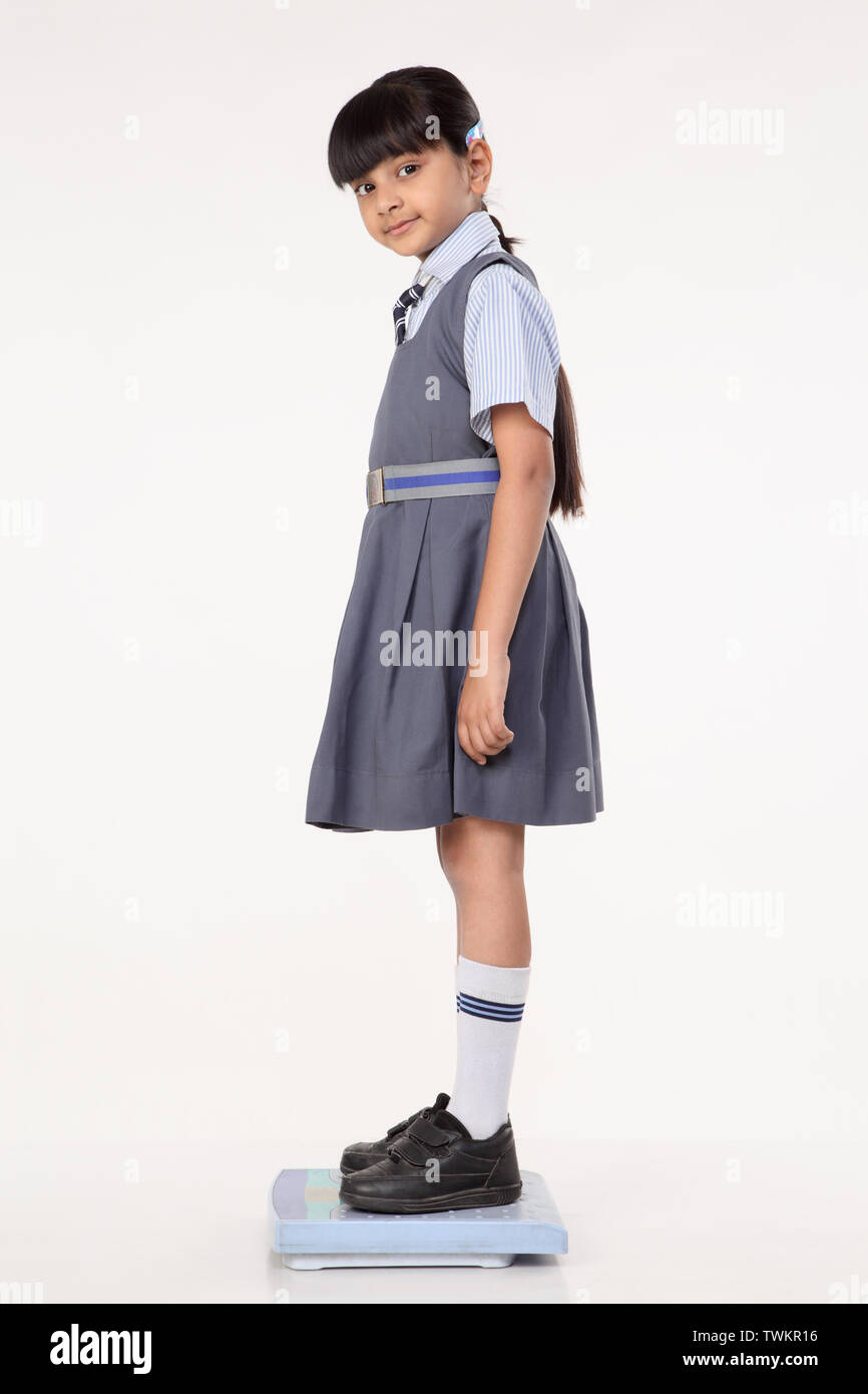 Girl weighing herself on a weight scale Stock Photo - Alamy