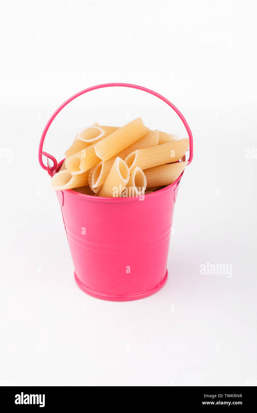 Heap pasta in pink bucket on white background. Copy space Stock Photo ...