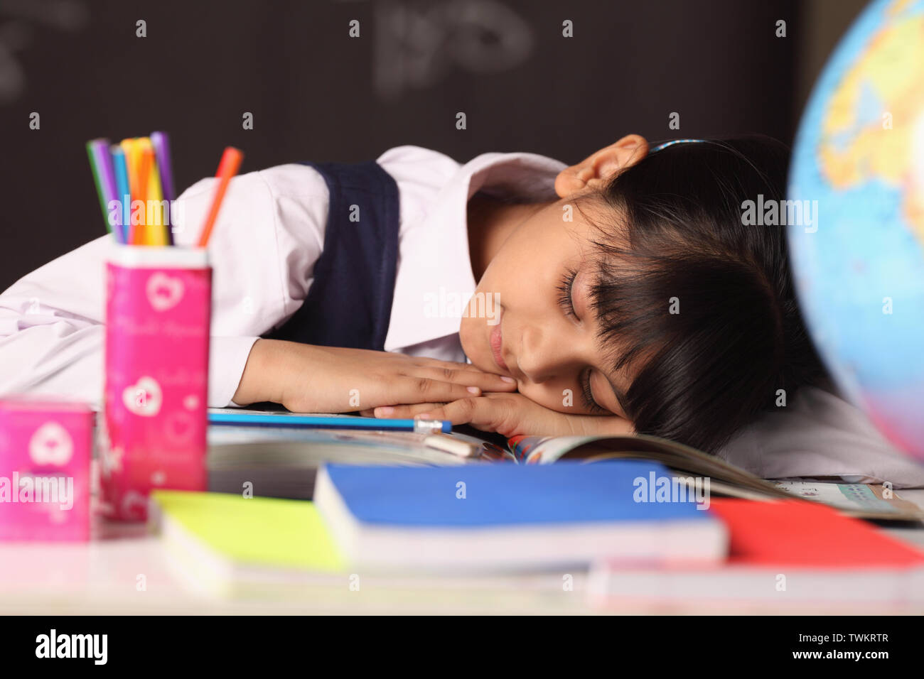 Schoolgirl napping on a desk in a classroom Stock Photo - Alamy