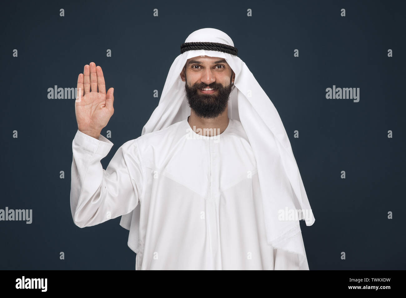 Half-length portrait of arabian saudi businessman on dark blue studio ...