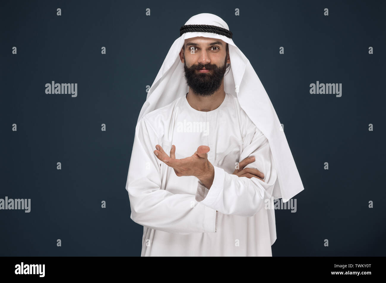 Half-length portrait of arabian saudi businessman on dark blue studio ...
