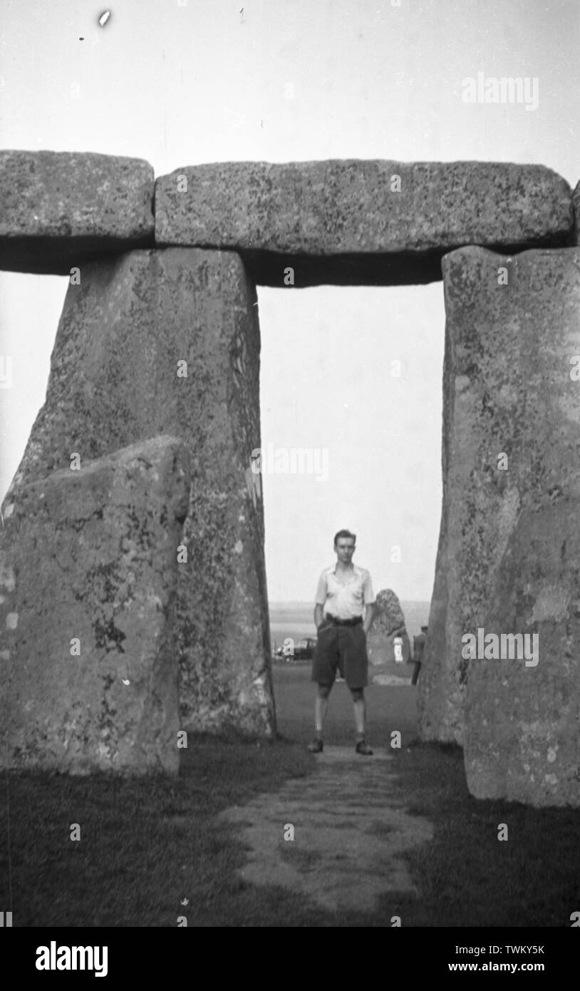Man Stands Between Columns Of Stone At Stonehenge, Wiltshire, England ...