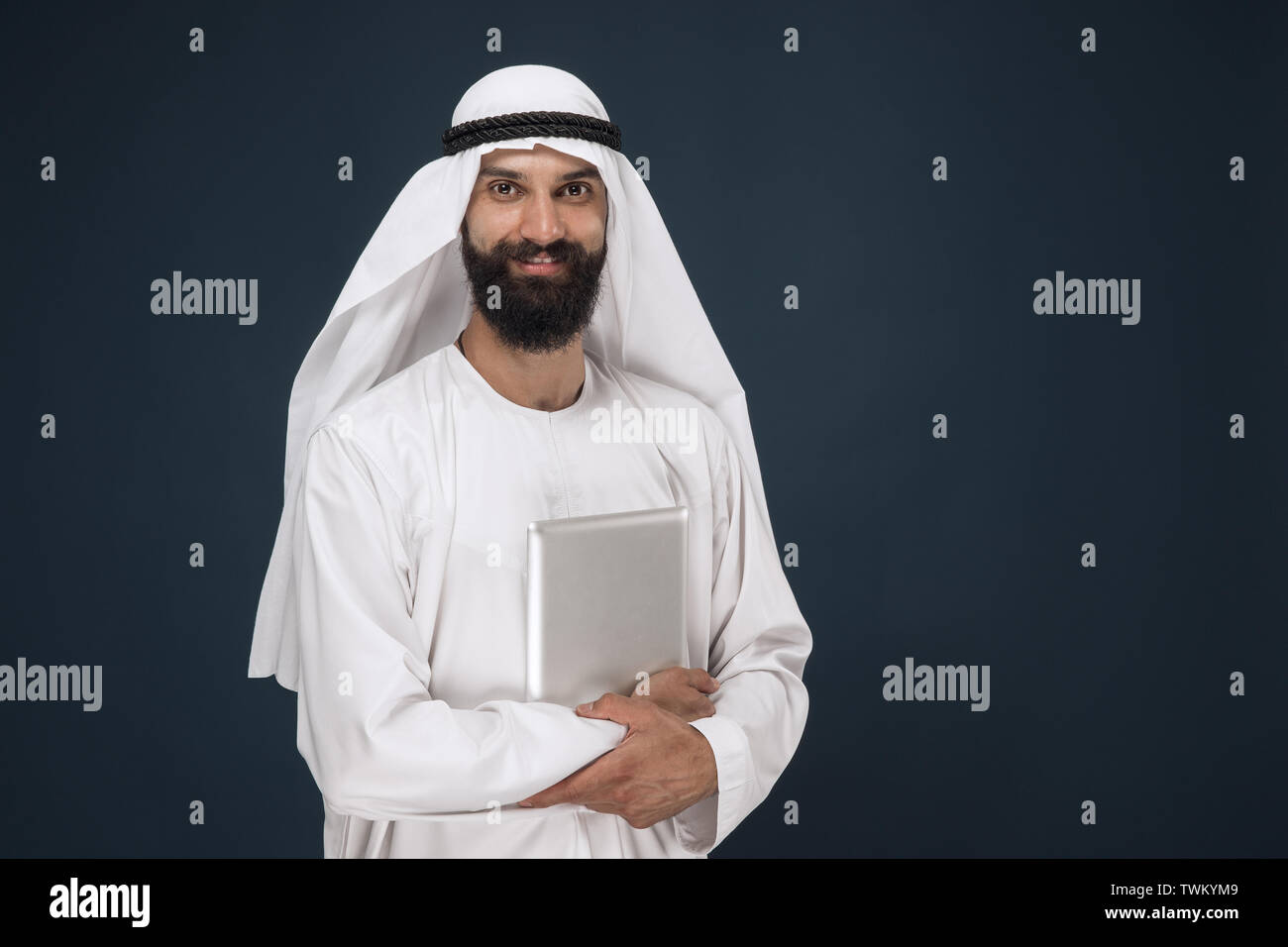 Half-length portrait of arabian saudi businessman on dark blue studio ...