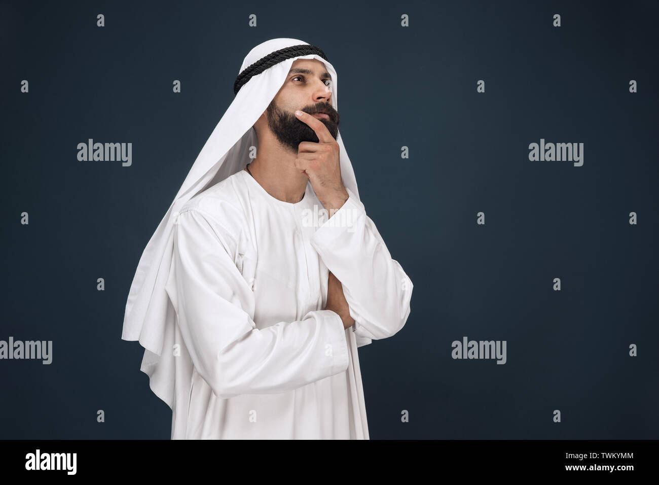 Half-length portrait of arabian saudi businessman on dark blue studio ...
