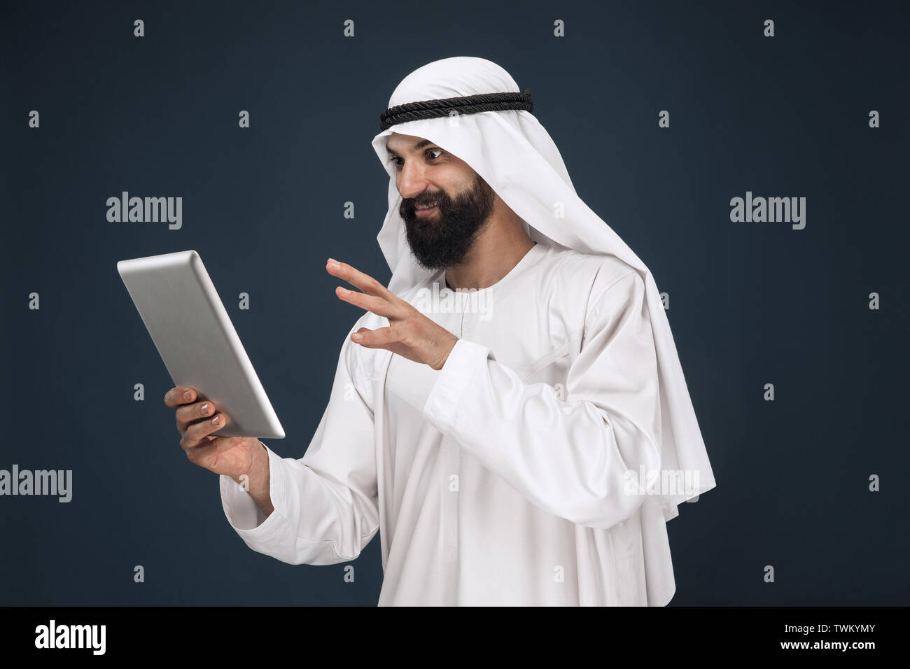 Half-length portrait of arabian saudi businessman on dark blue studio ...