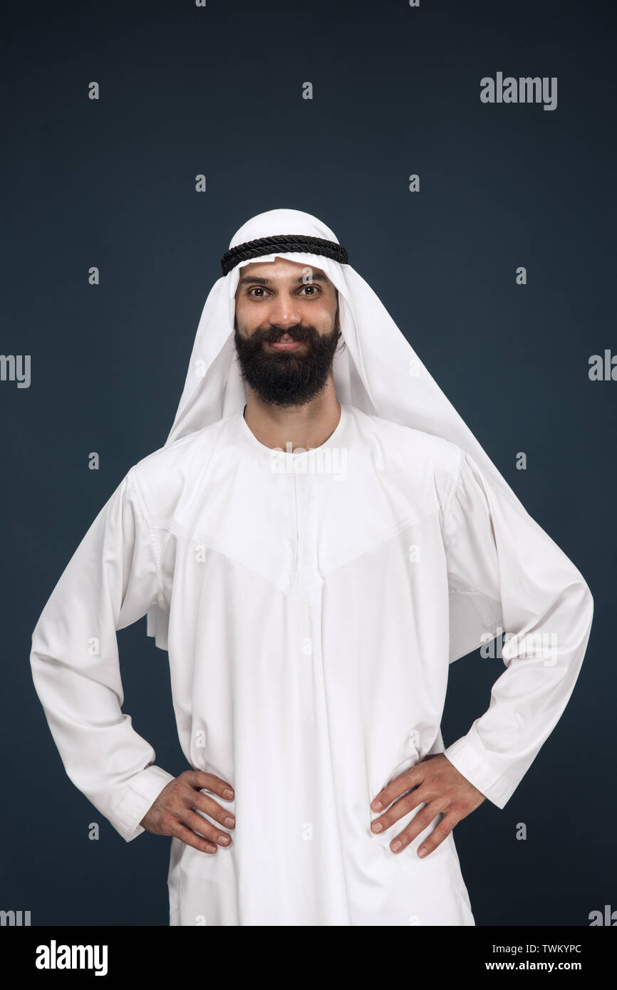 Half-length portrait of arabian saudi businessman on dark blue studio ...
