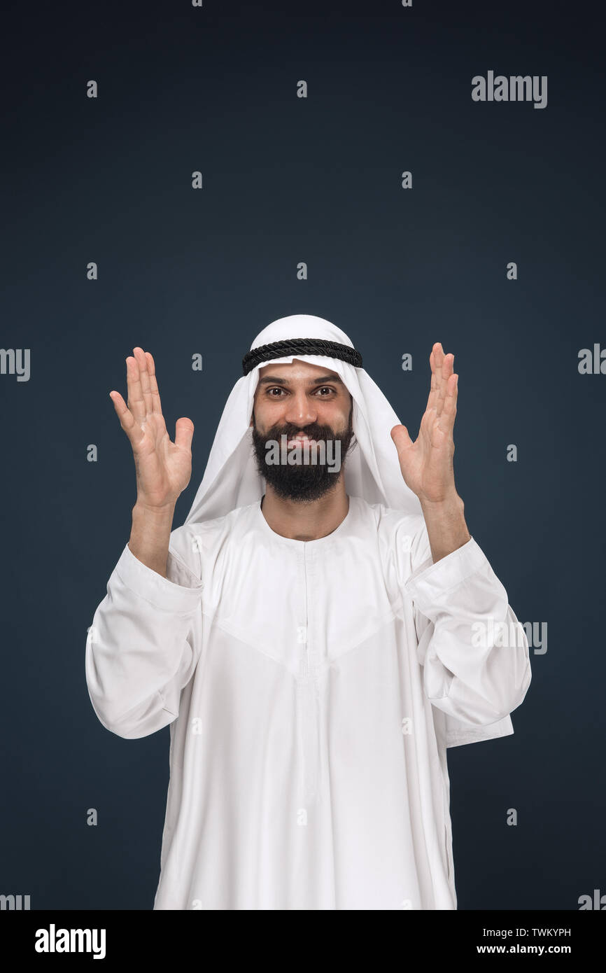 Half-length portrait of arabian saudi businessman on dark blue studio ...