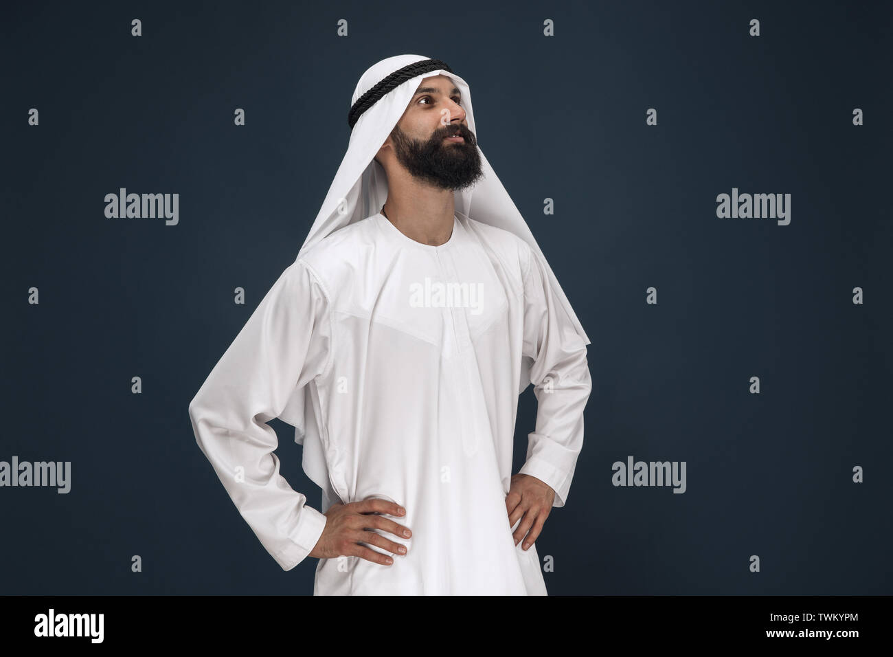 Half-length portrait of arabian saudi businessman on dark blue studio ...