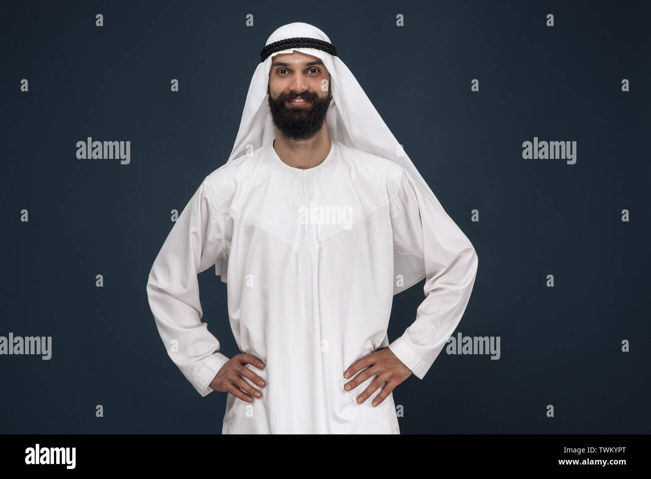 Half-length portrait of arabian saudi businessman on dark blue studio ...