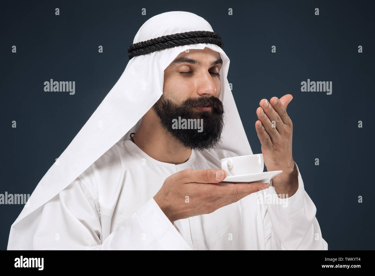 Half-length portrait of arabian saudi businessman on dark blue studio ...