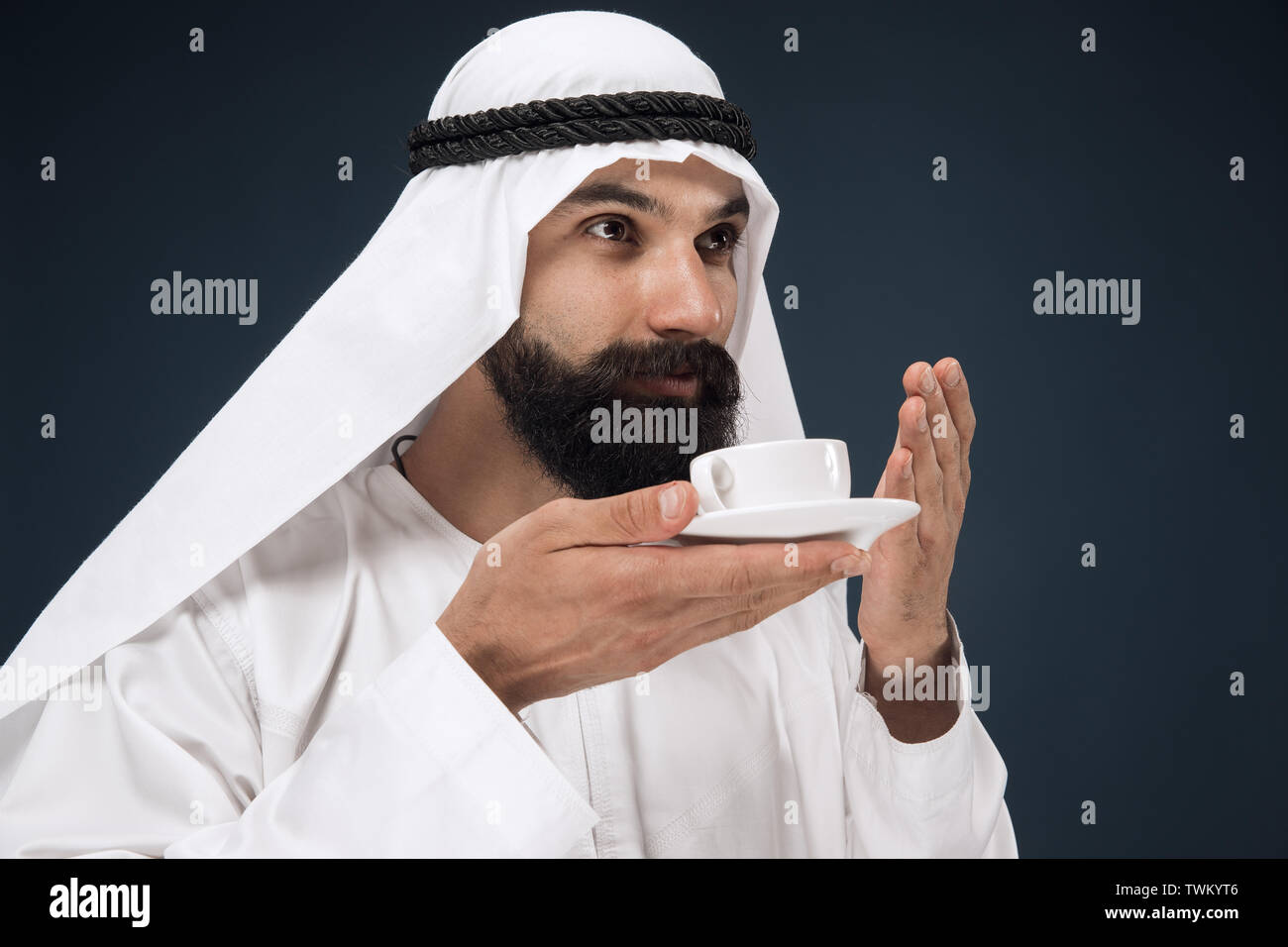 Half-length portrait of arabian saudi businessman on dark blue studio ...
