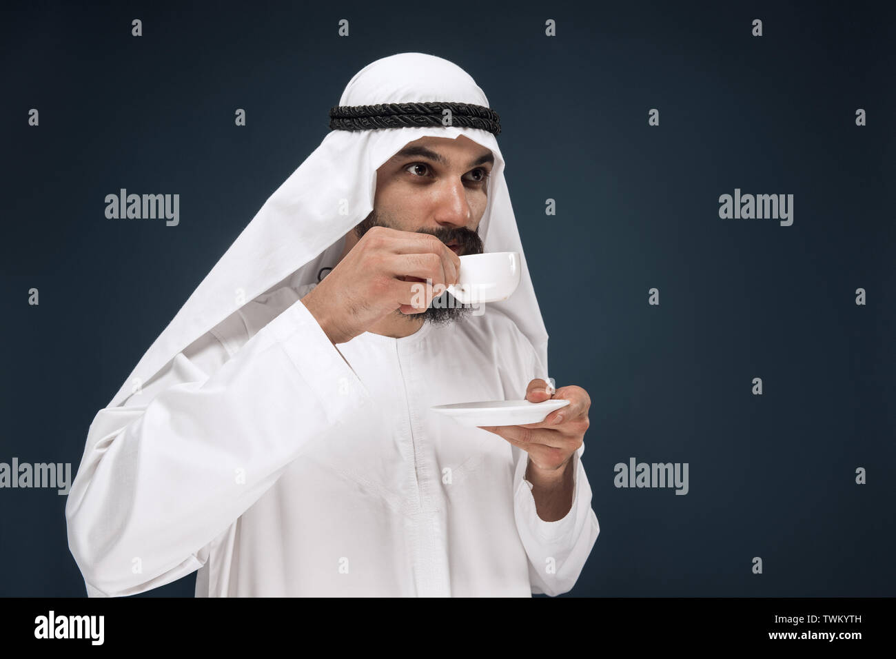Half-length portrait of arabian saudi businessman on dark blue studio ...