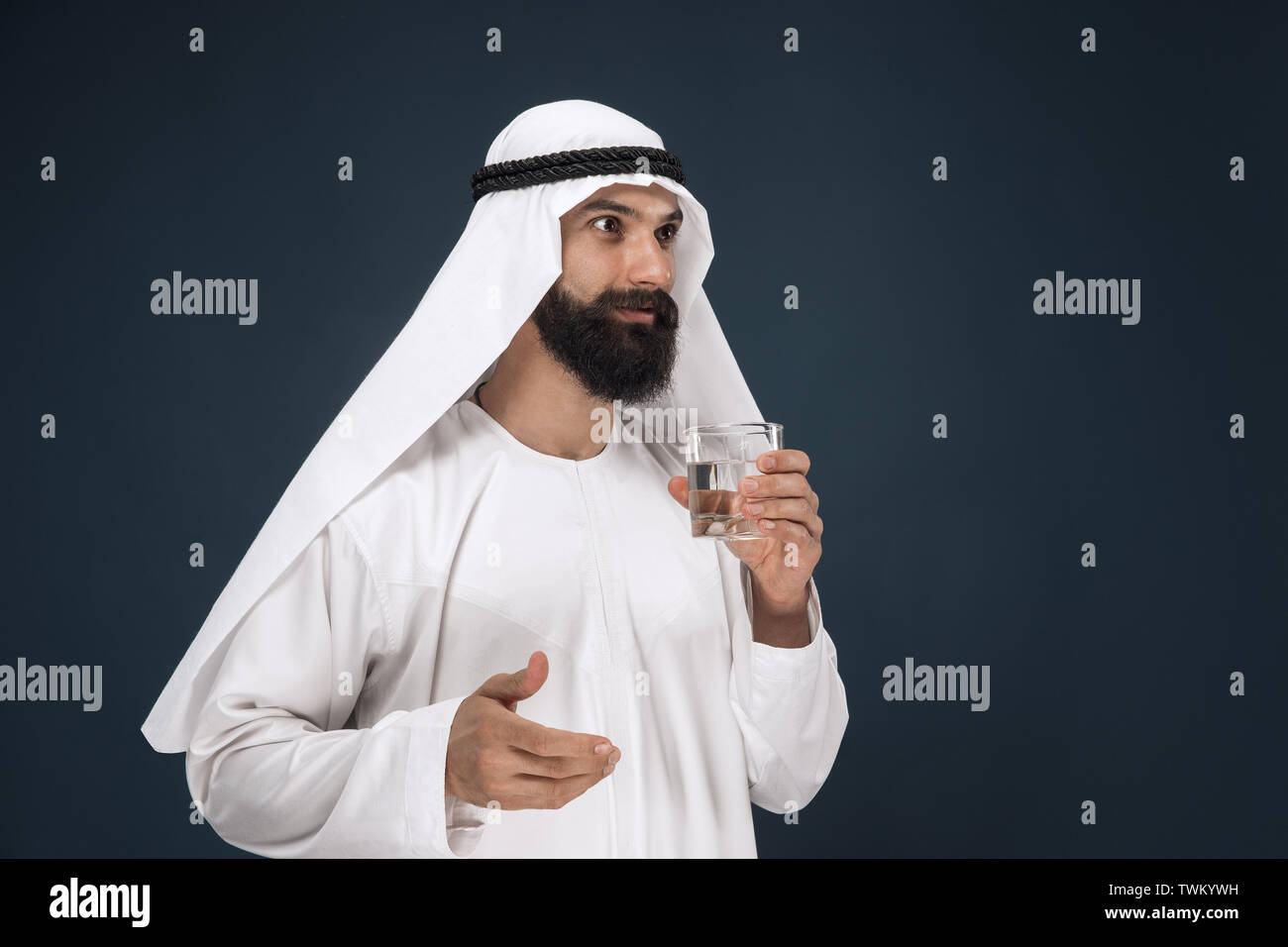 Half-length portrait of arabian saudi businessman on dark blue studio ...