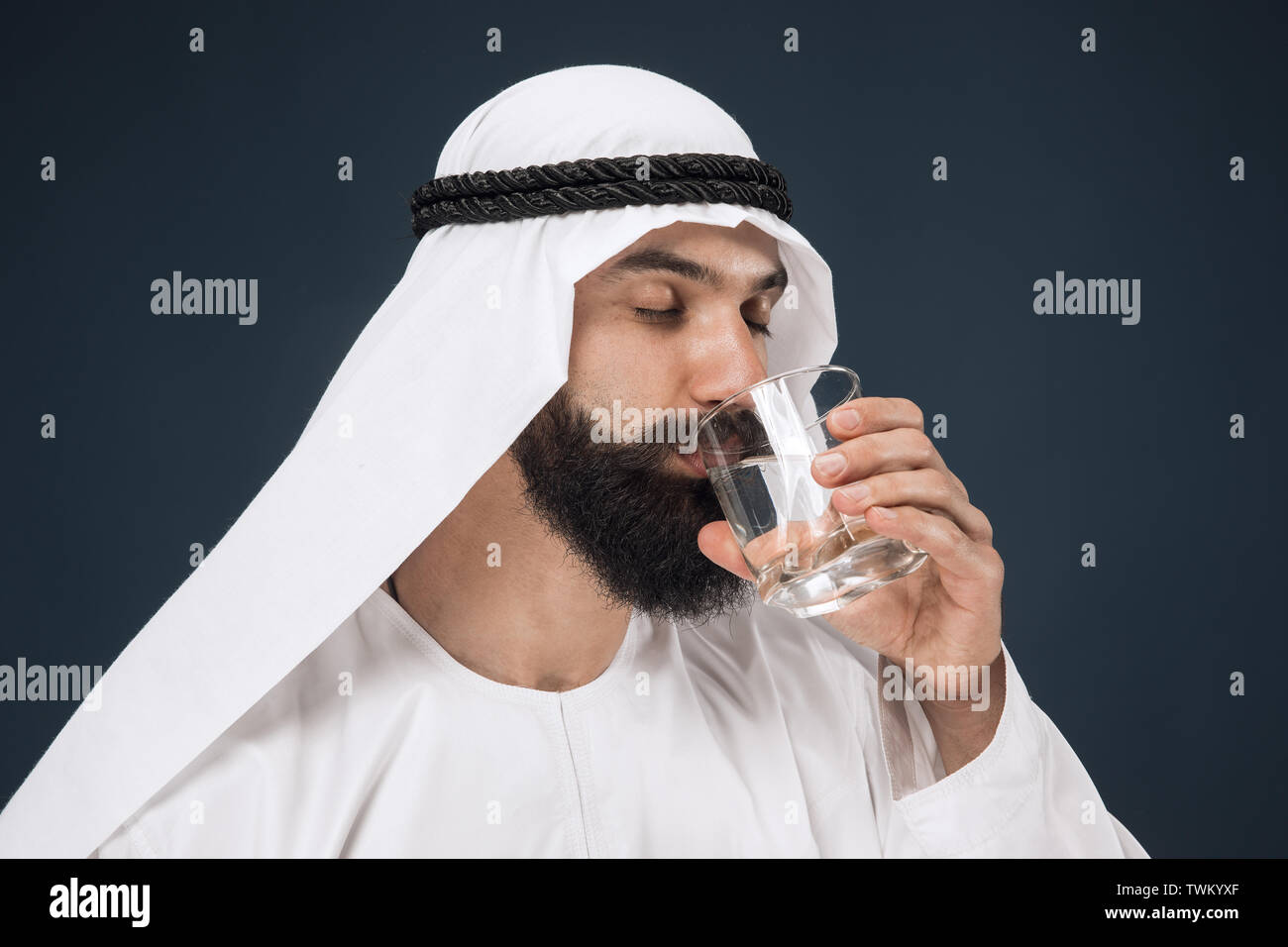 Half-length portrait of arabian saudi businessman on dark blue studio ...