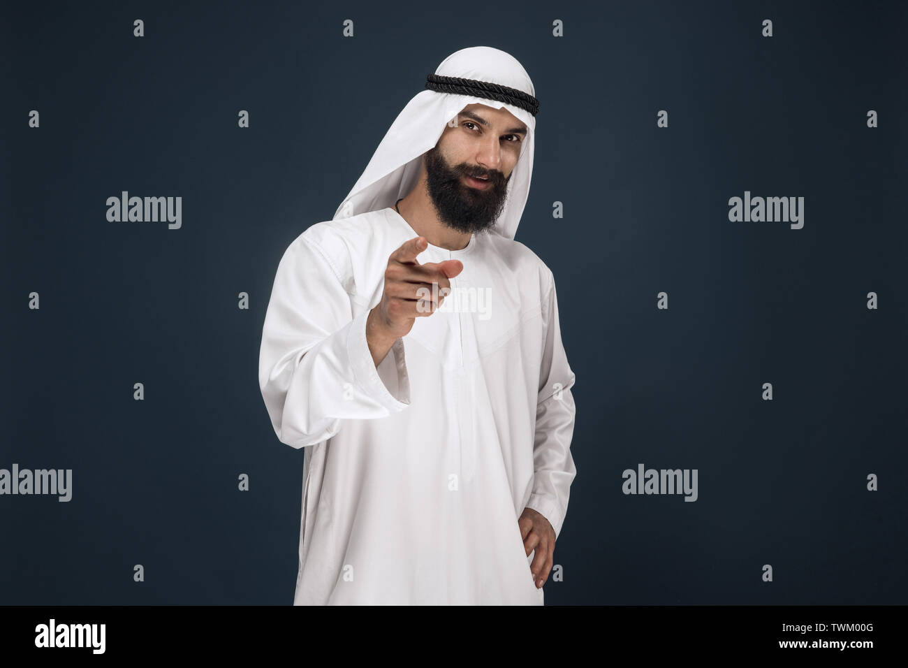 Half-length portrait of arabian saudi businessman on dark blue studio ...