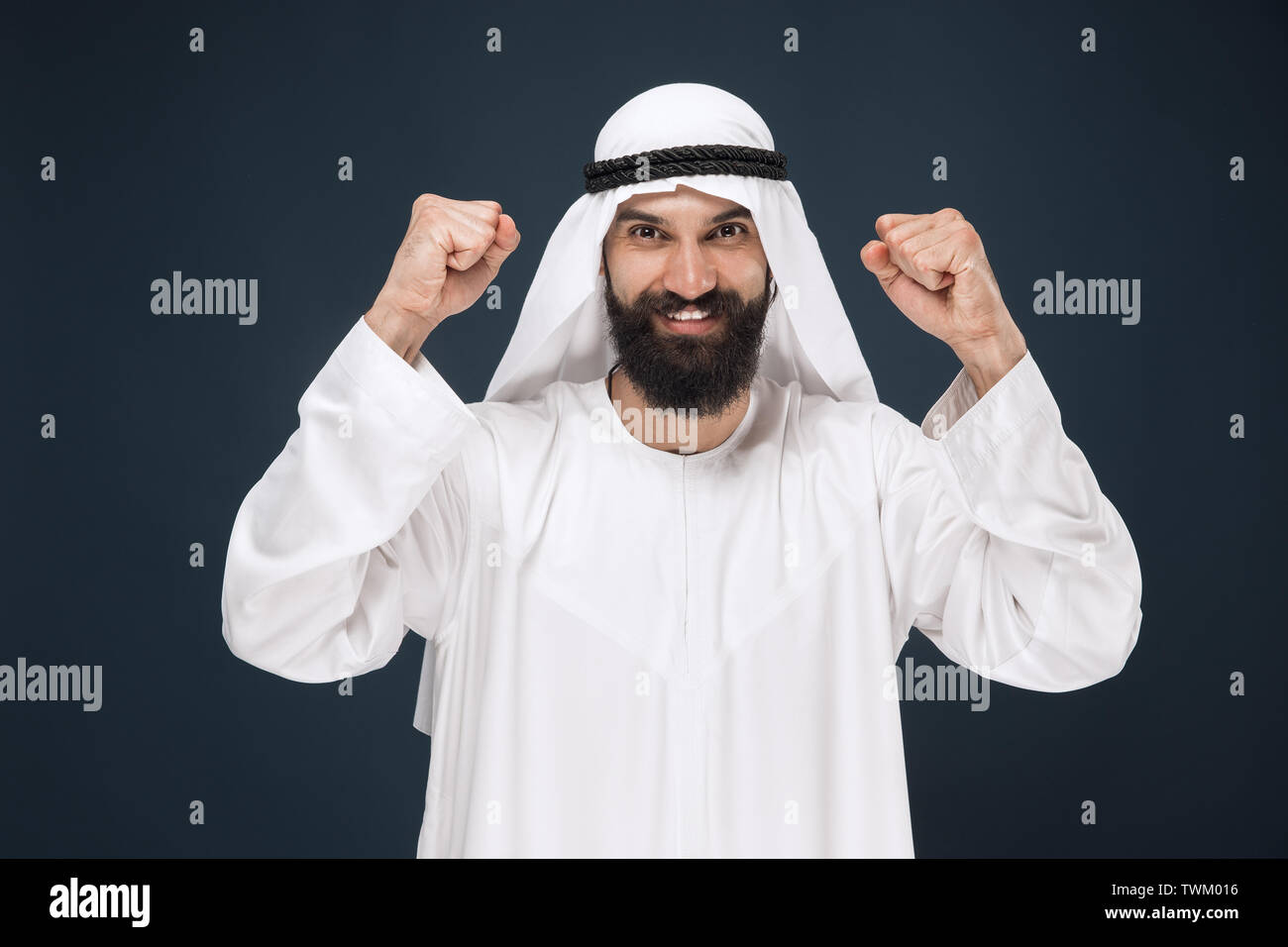 Portrait of arabian saudi businessman on dark blue studio background ...