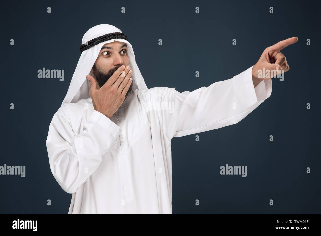 Half-length portrait of arabian saudi businessman on dark blue studio ...