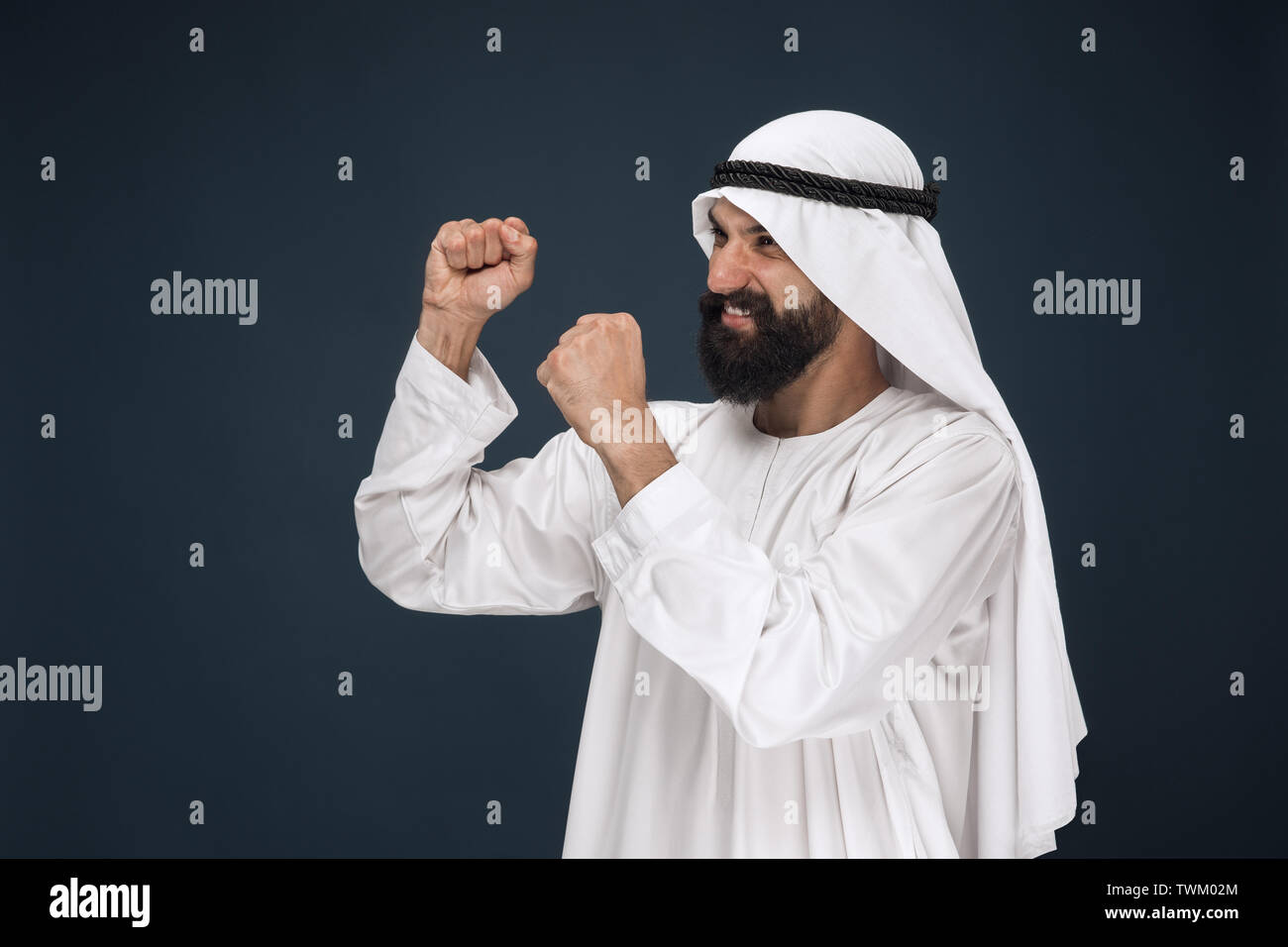 Portrait of arabian saudi businessman on dark blue studio background ...