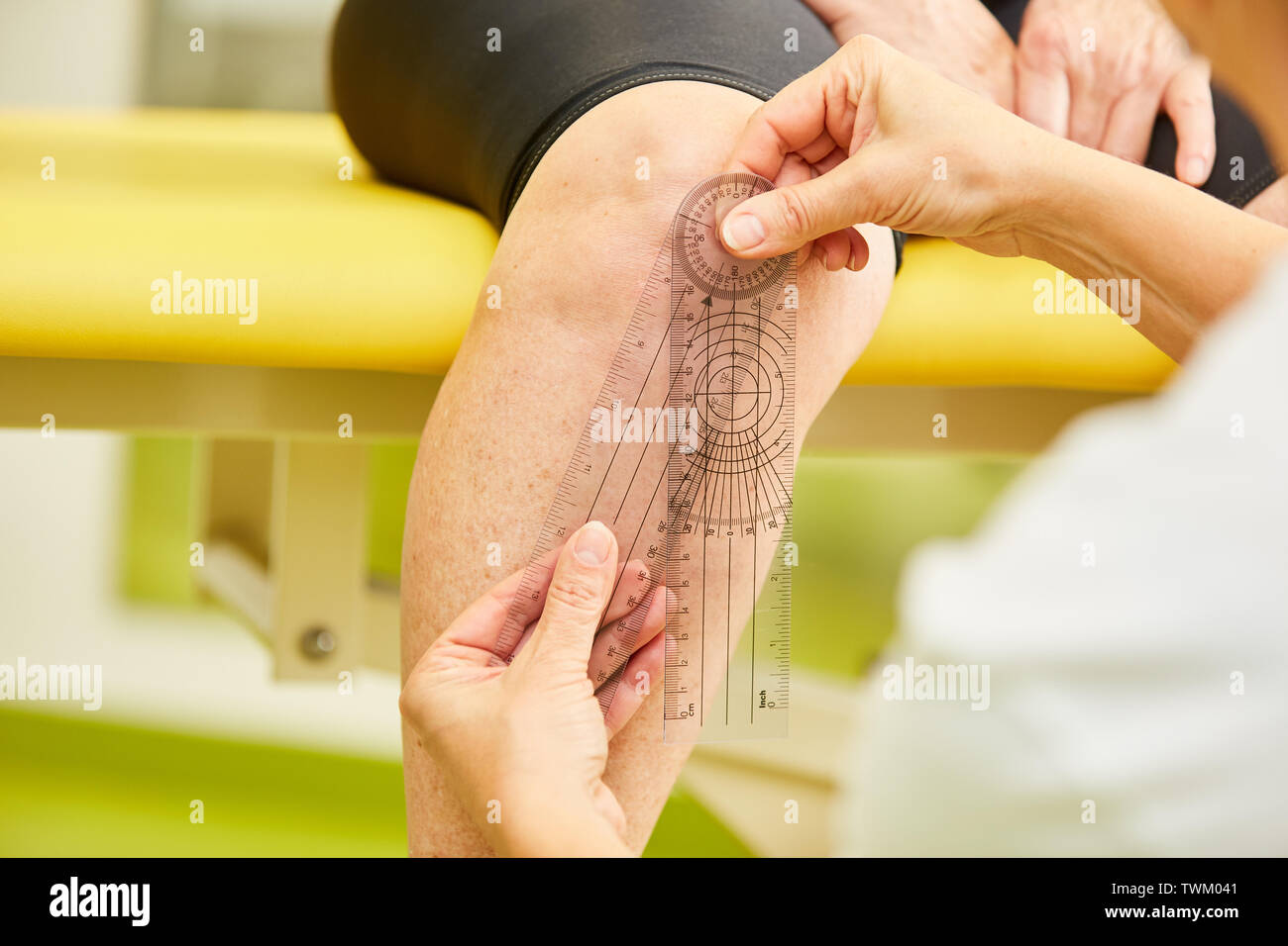 Physiotherapist measures mobility in the knee joint of a patient with ...