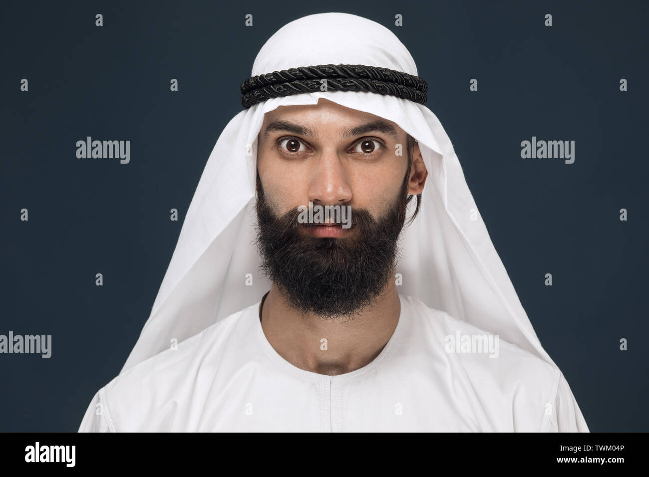 Half-length portrait of arabian saudi businessman on dark blue studio ...