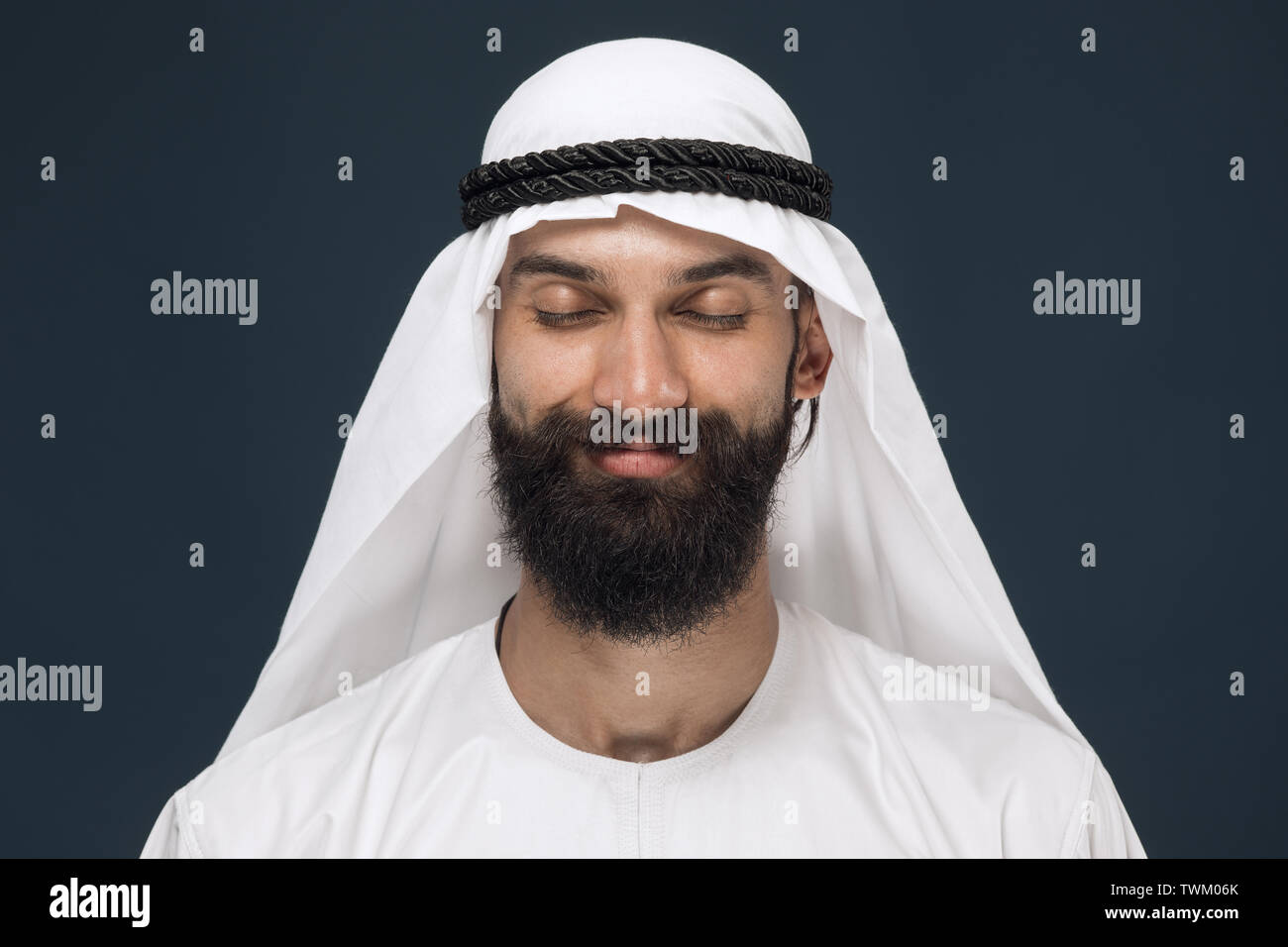 Half-length portrait of arabian saudi businessman on dark blue studio ...