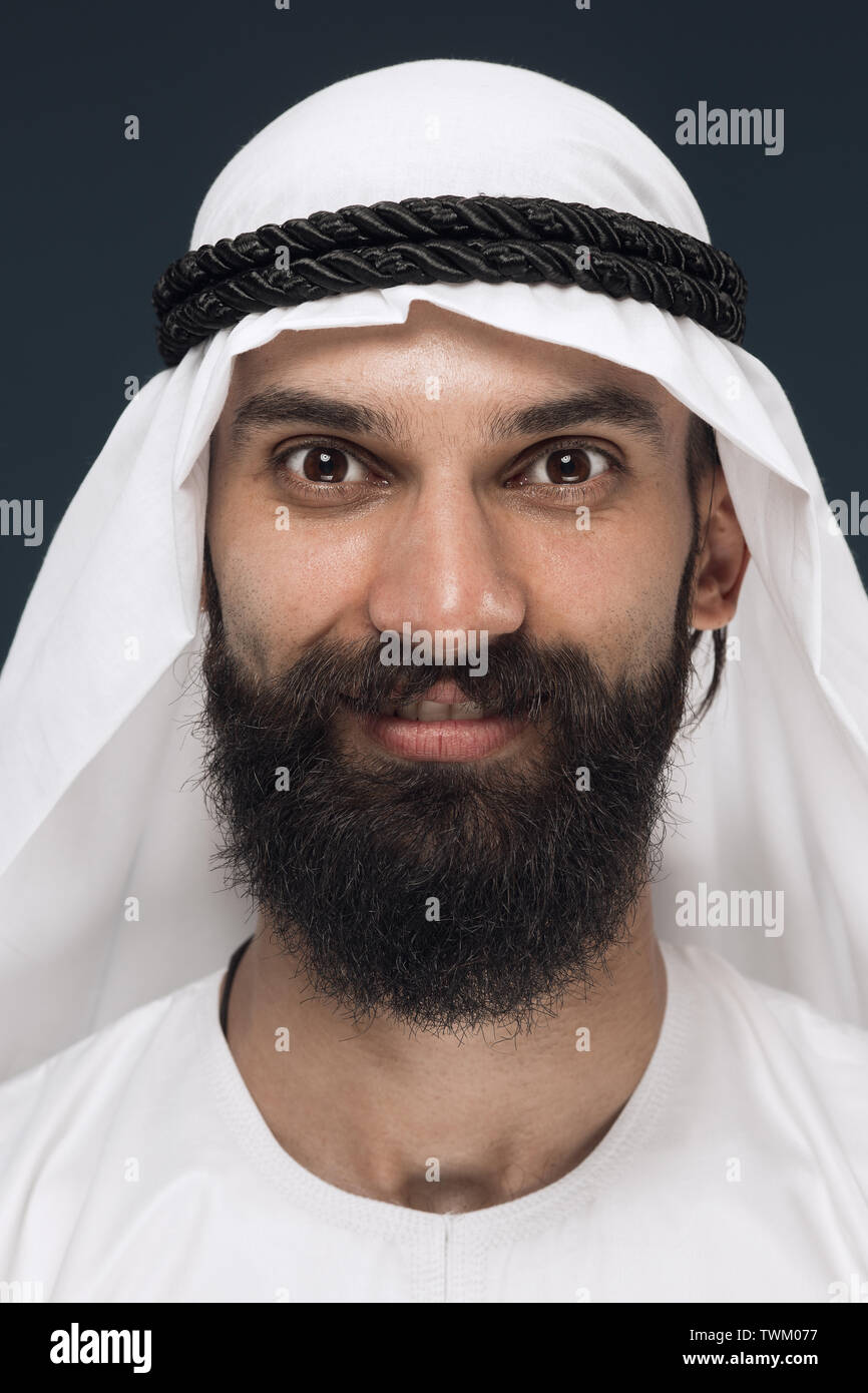 Close up portrait of arabian saudi businessman on dark blue studio ...