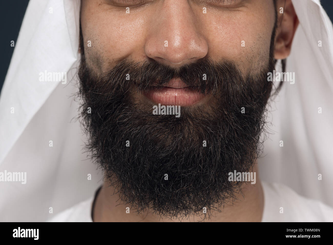 Close up portrait of arabian saudi businessman on dark blue studio ...